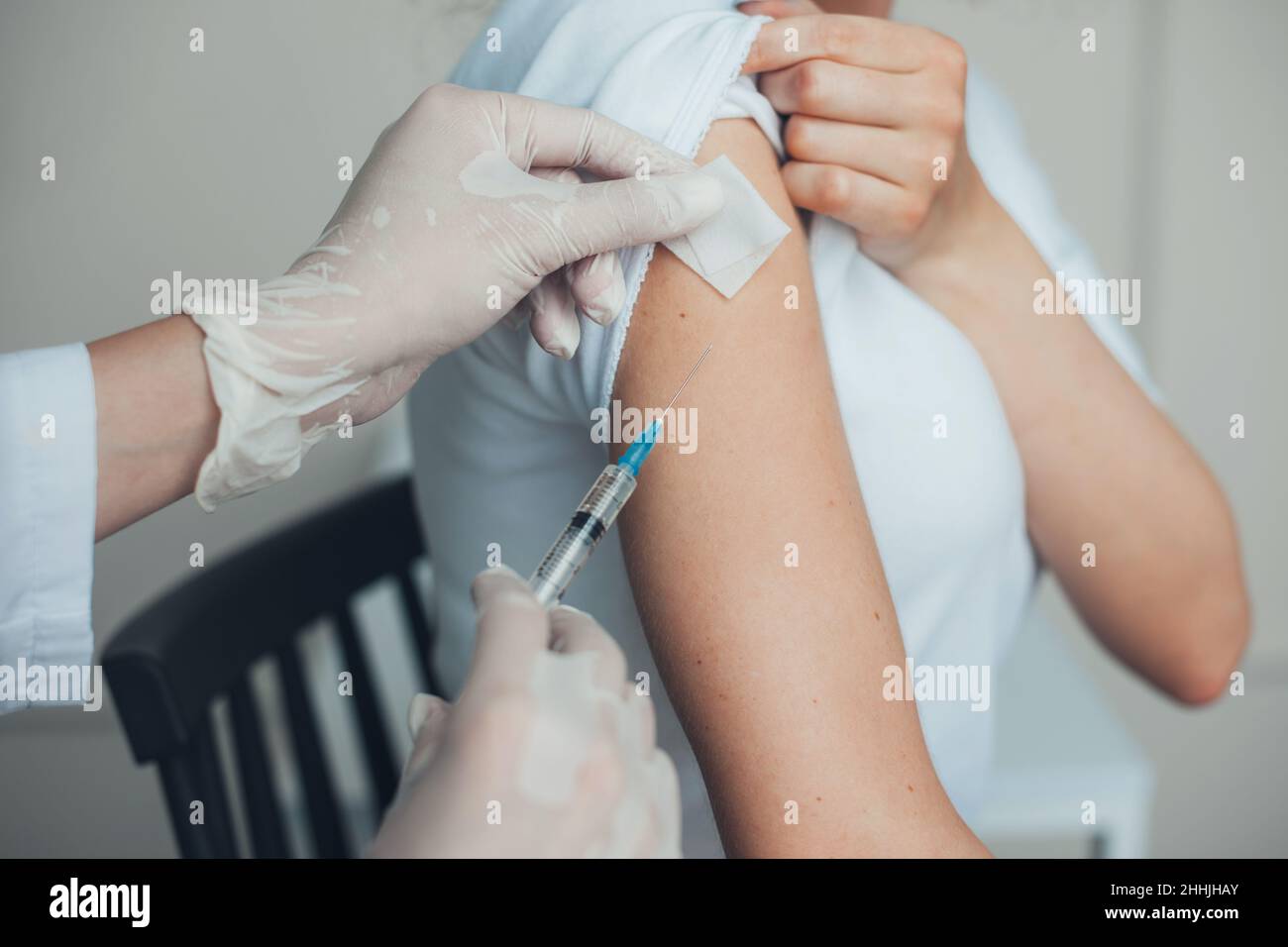 Closeup portrait of doctor's hands giving injection to patient's arm at ...