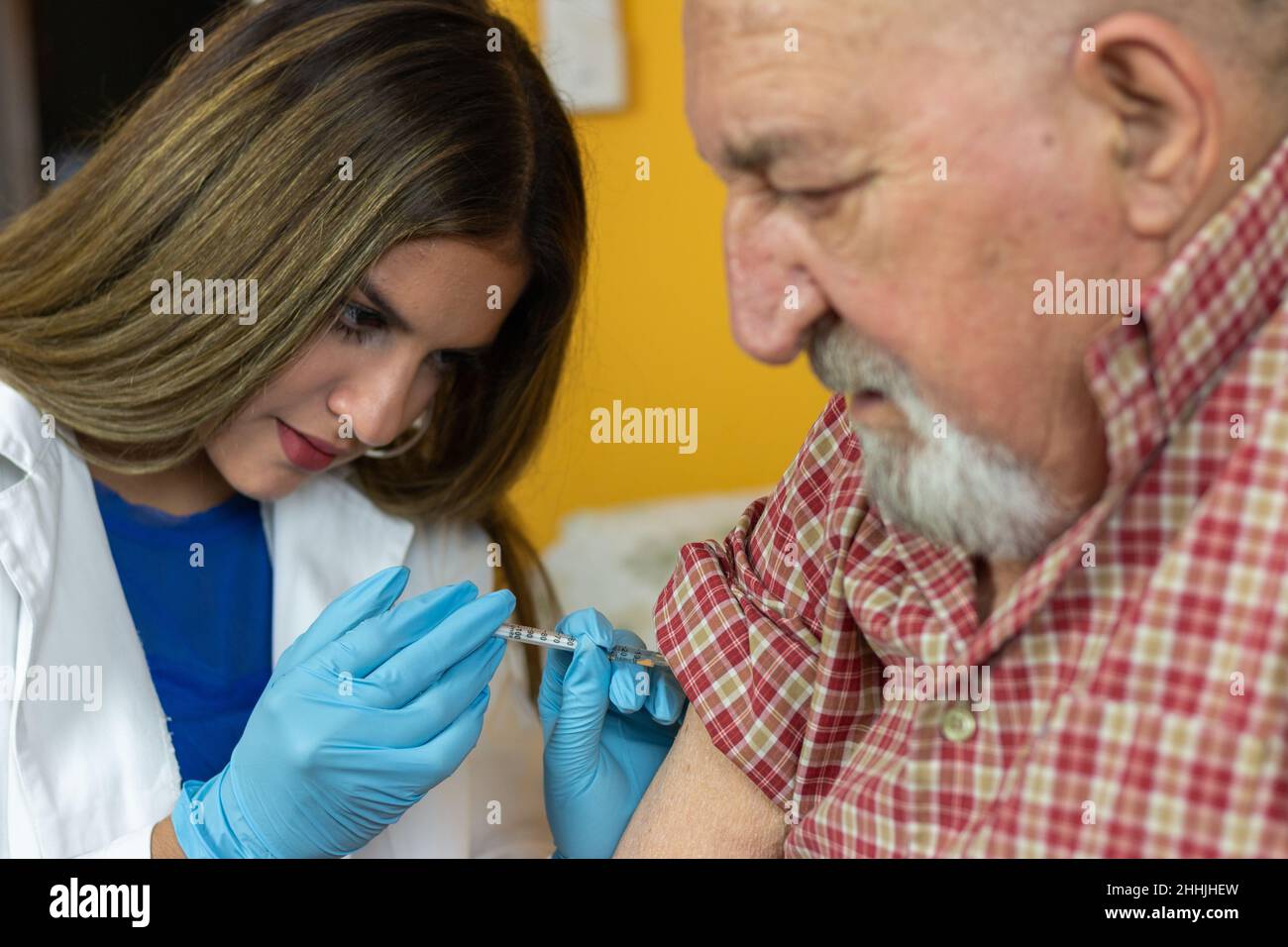 The doctor gives the vaccine to the pensioner at his home Stock Photo ...