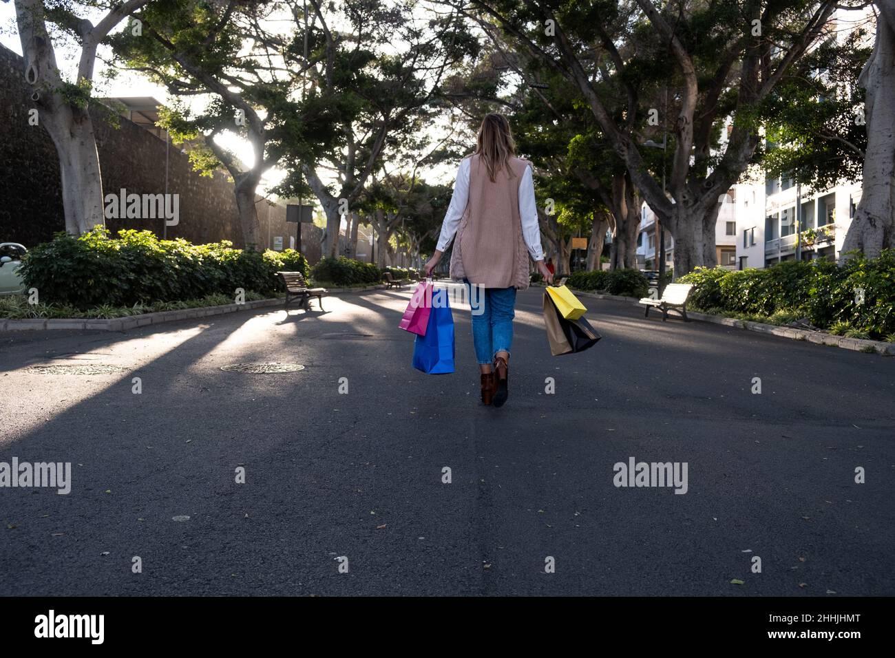 young woman from behind carrying paper shopping bags Stock Photo - Alamy