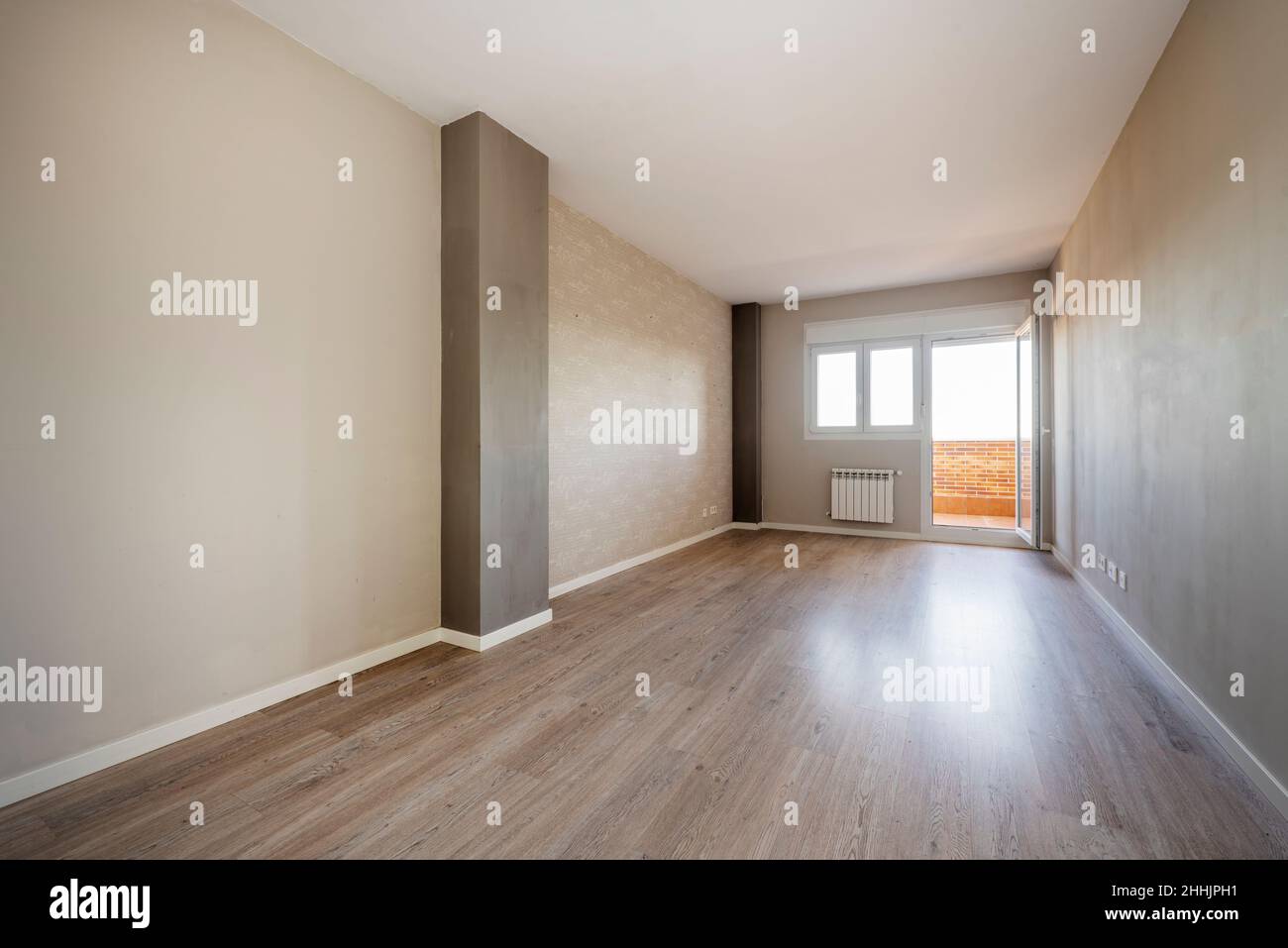 Empty living room with access to a terrace with brick walls and ...