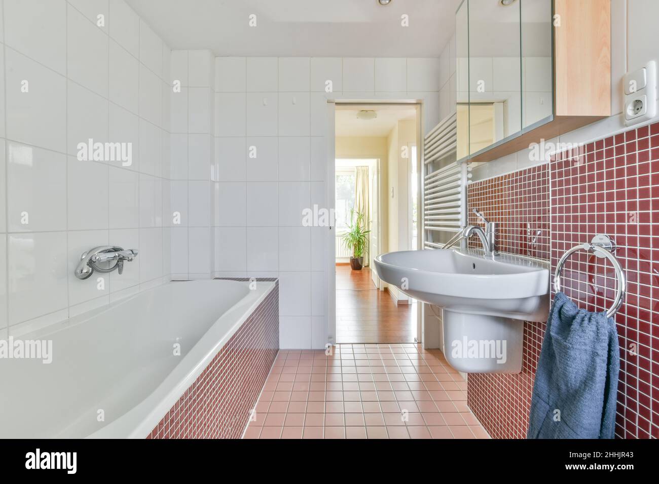 White sink placed at wall near toilet in light bathroom with ceramic ...