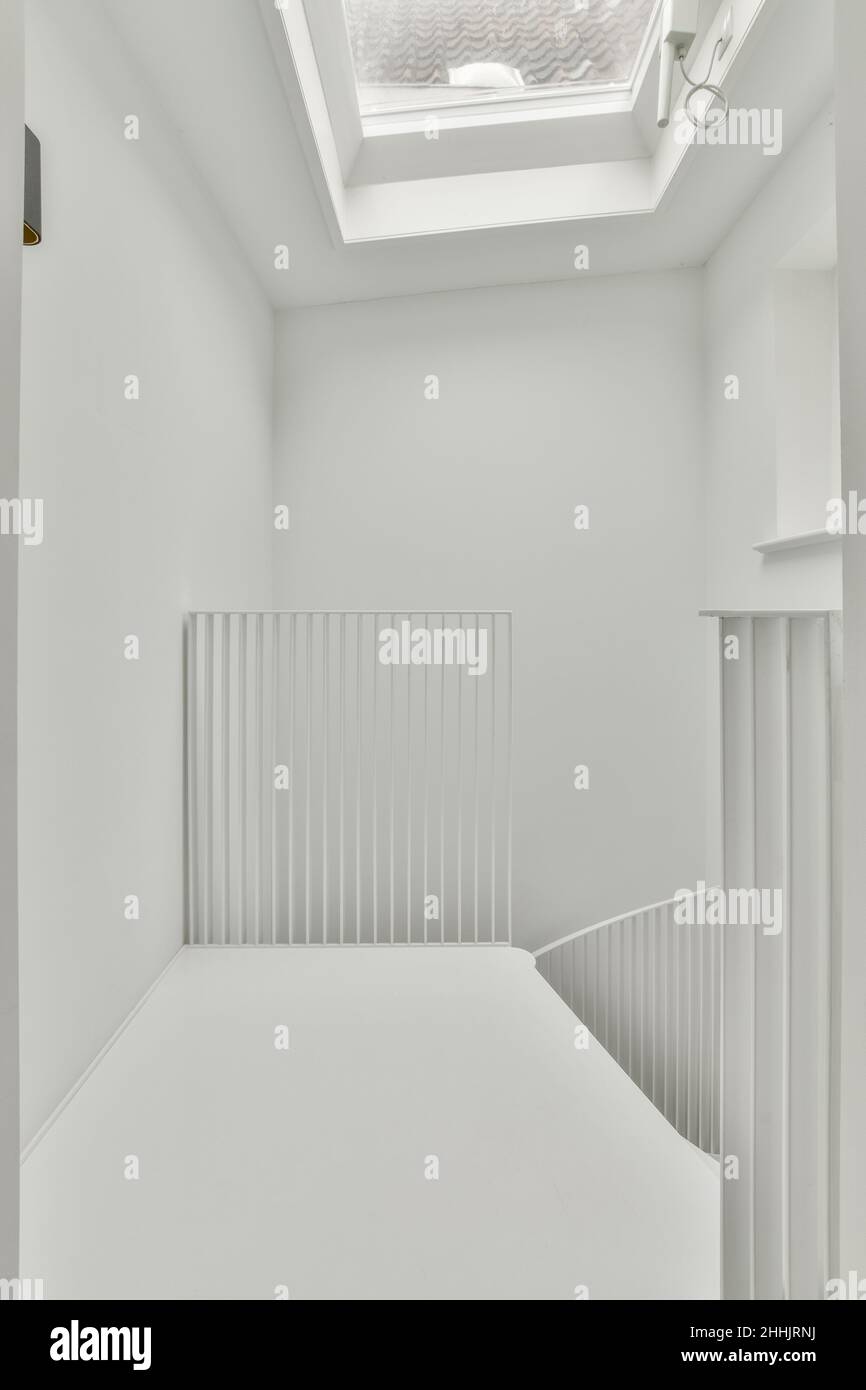 Small empty light hallway in white color with simple railing and hatch ...