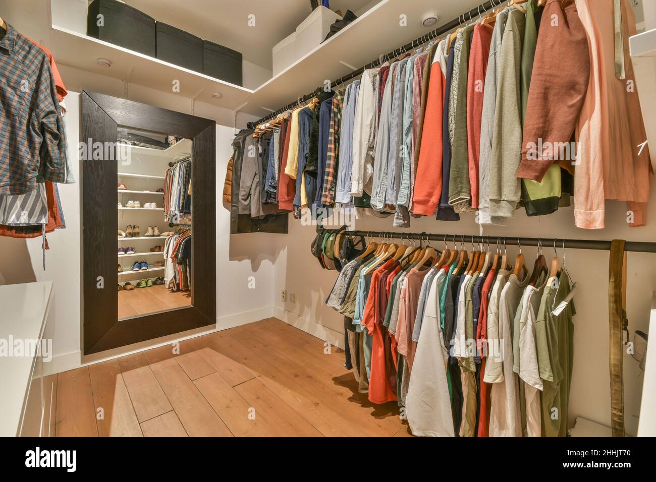 Interior of modern dressing room with mirror and shelves and rows of ...