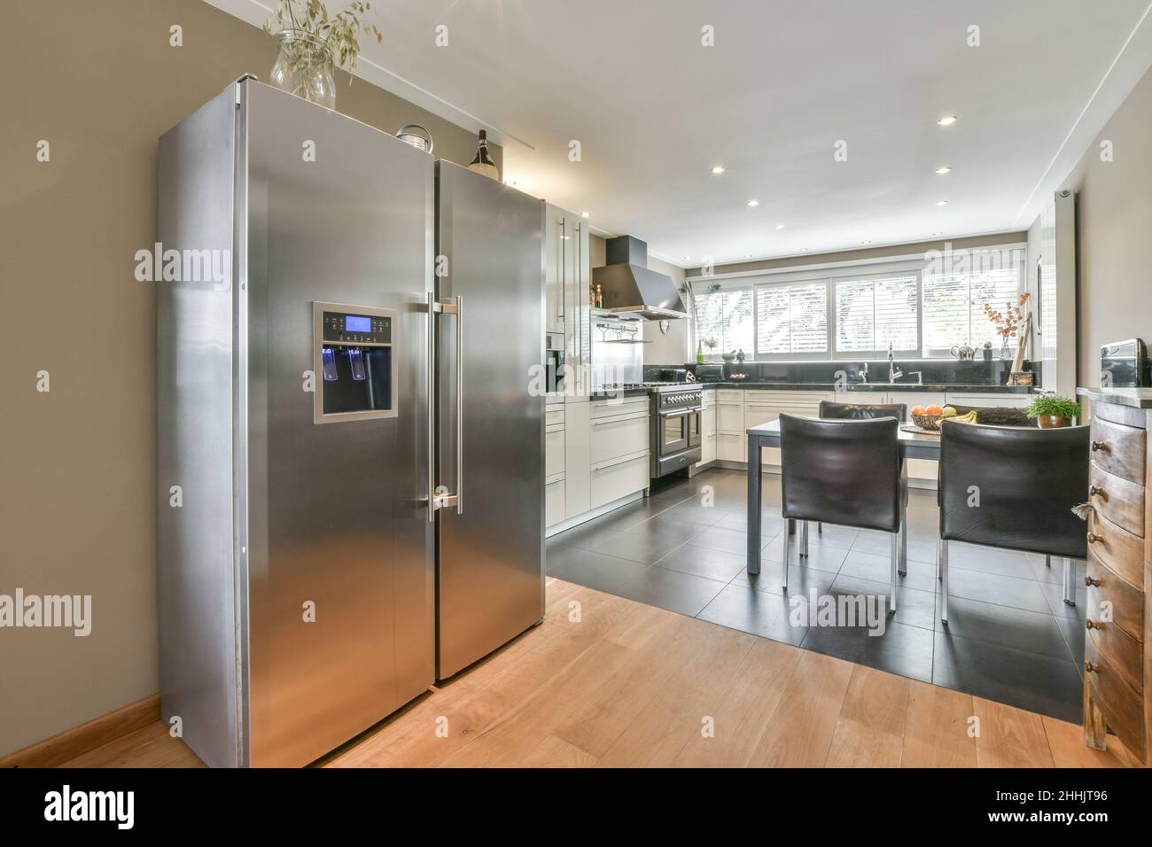 Large silver refrigerator in modern spacious kitchen with white ...