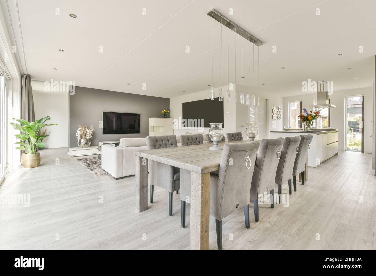 Comfortable chairs around wooden dining table in big house with living ...