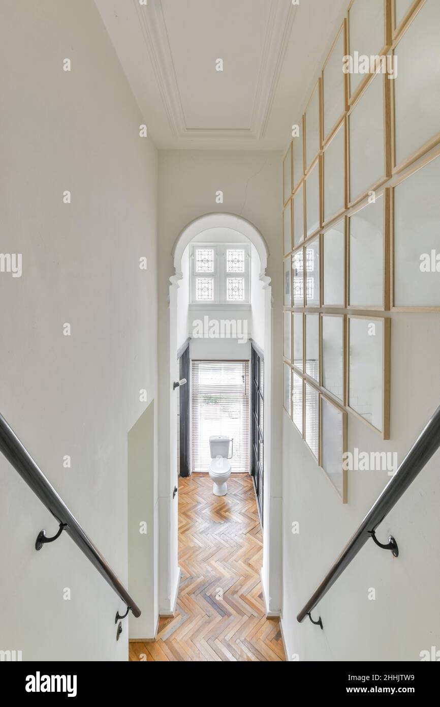 From above interior of narrow hallway with arched doorway and stairwell ...