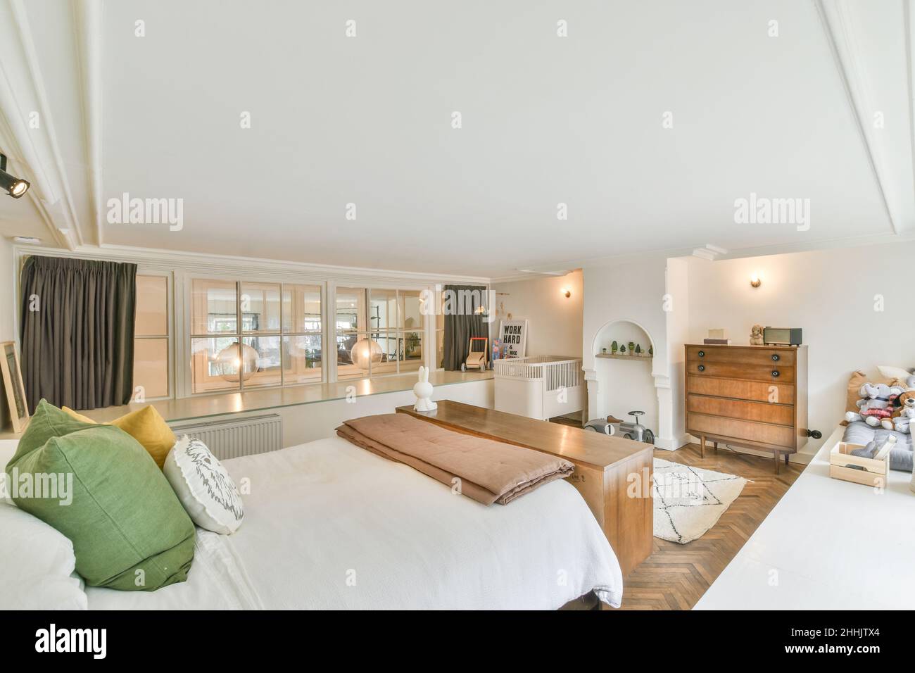 Interior of contemporary bedroom with baby cot and carpet and ...