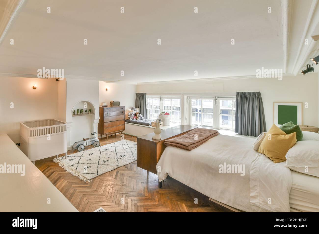 Interior of contemporary bedroom with baby cot and carpet and ...