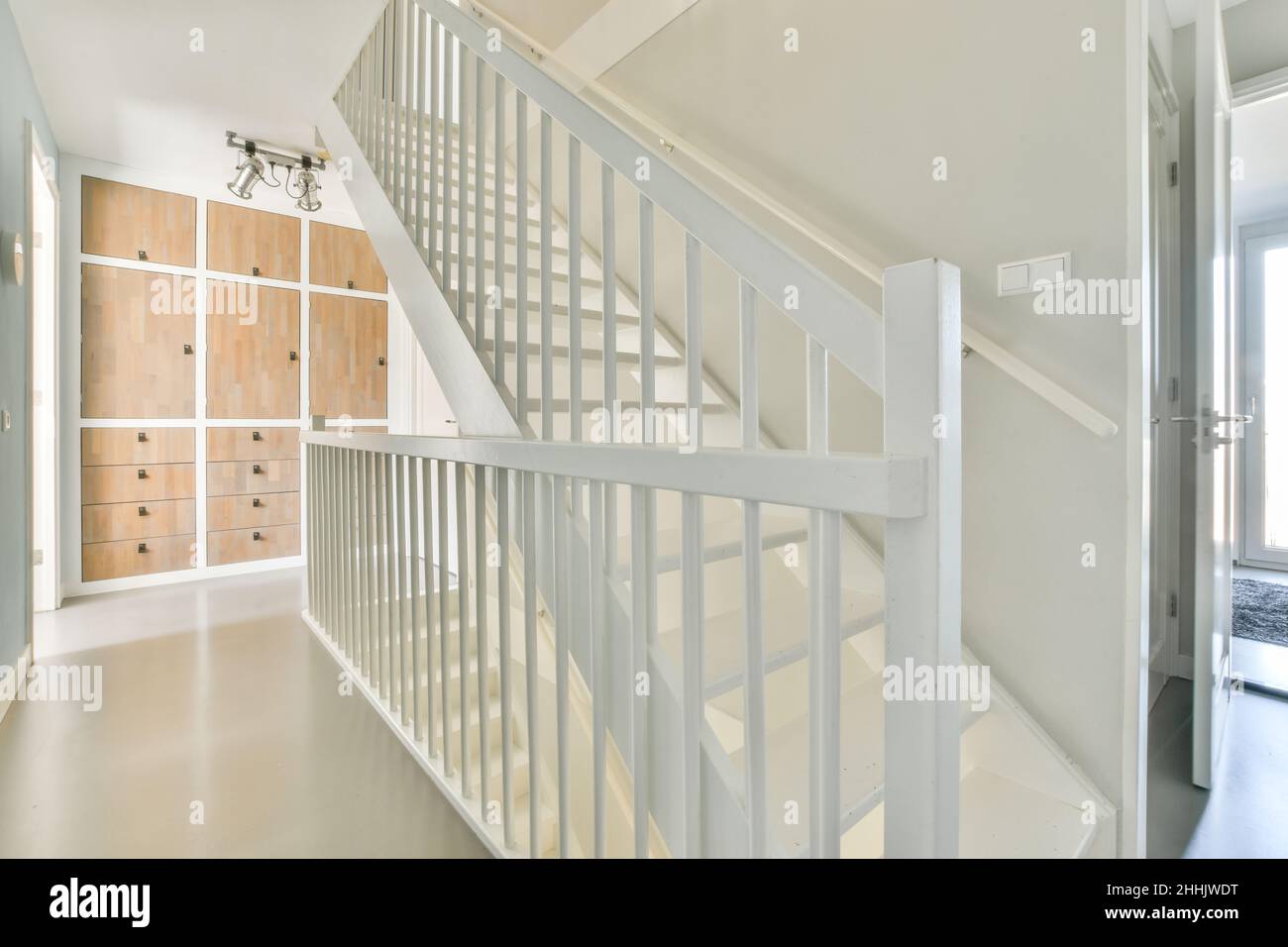 Interior of modern staircase with white wooden banisters and built in ...