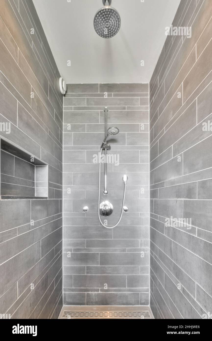 Interior of modern shower cabin with tiled walls and built in shelf and ...