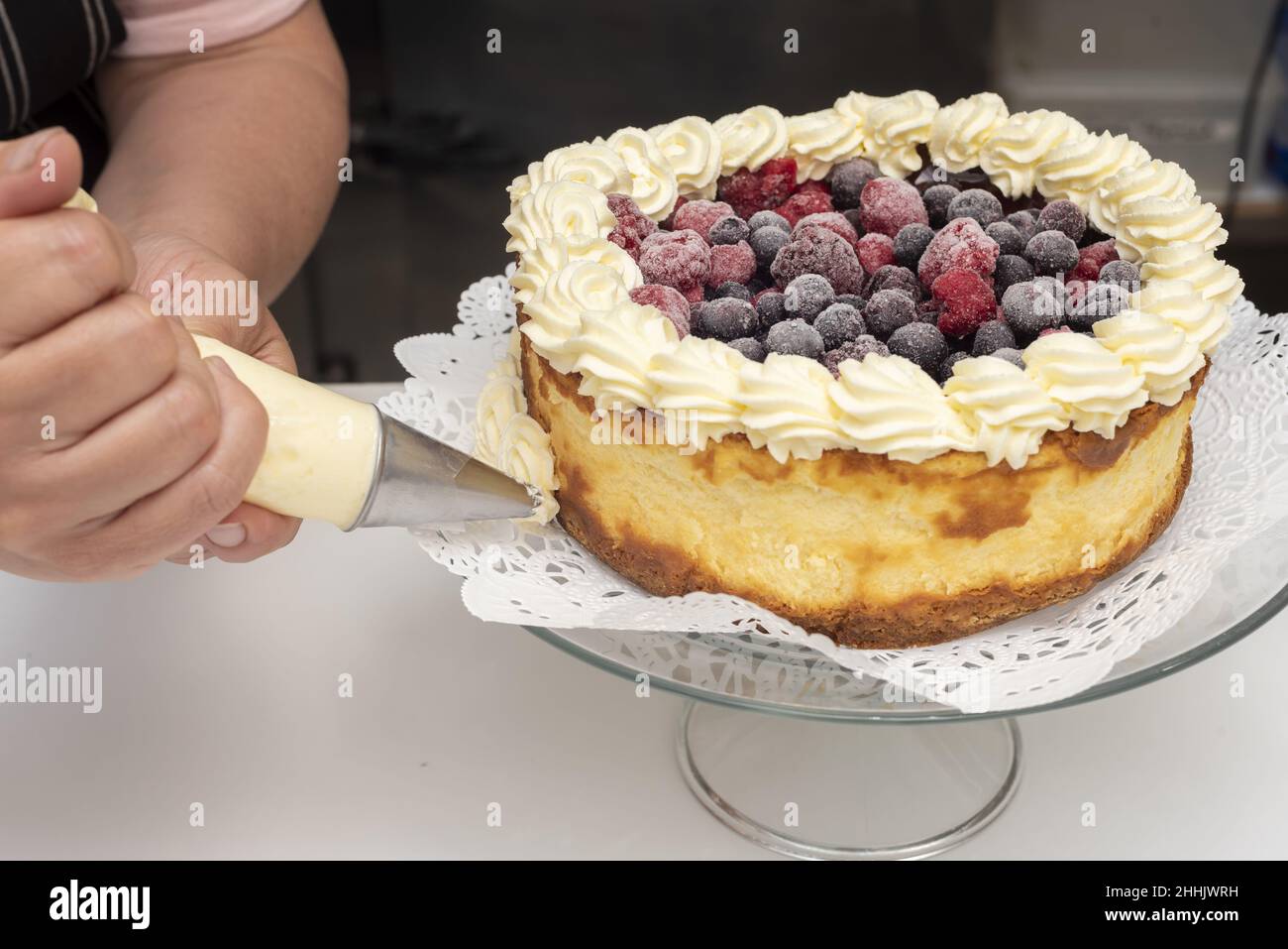 Pastry chef decorating the cheesecake with white cream Stock Photo - Alamy