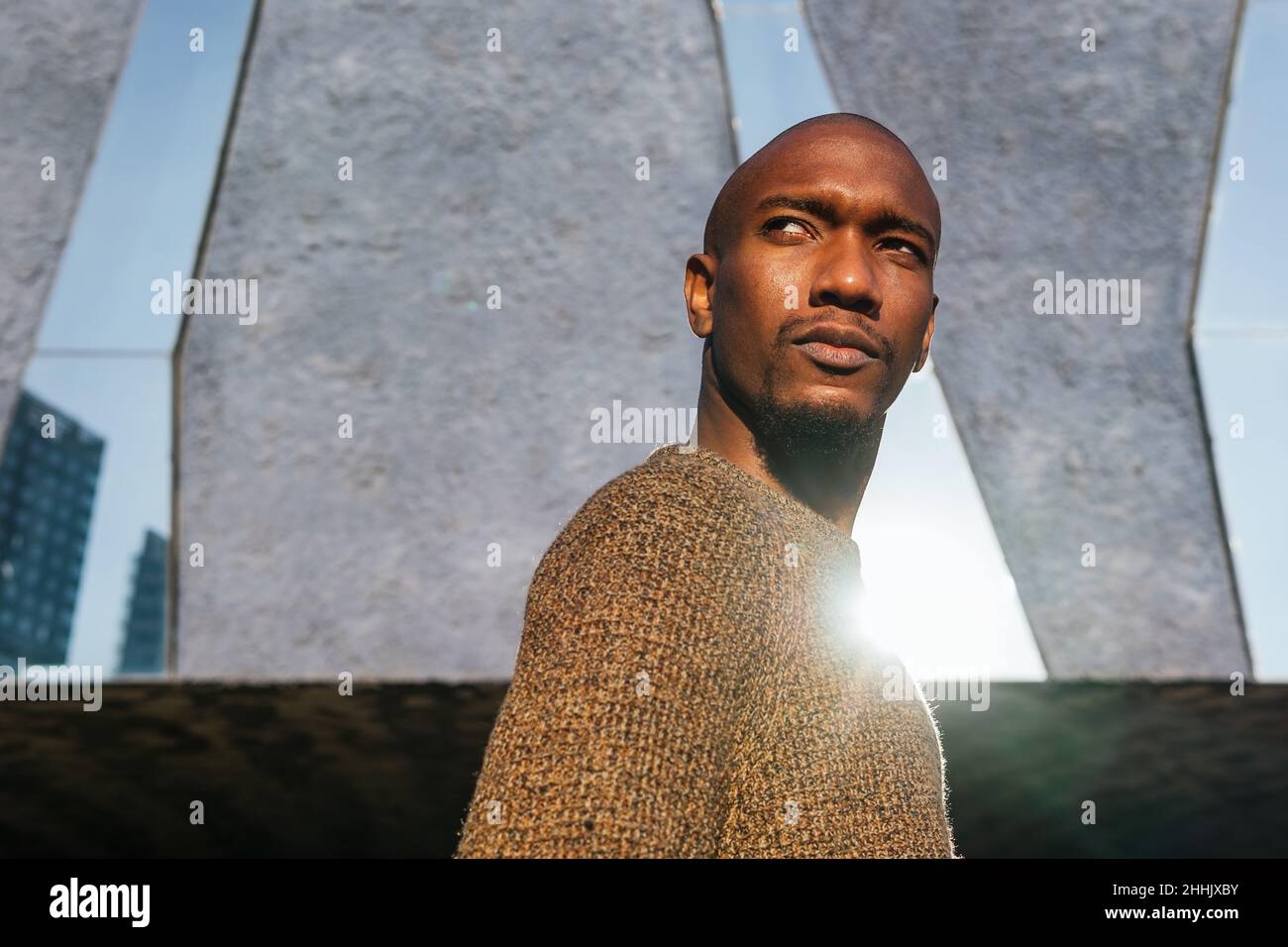 Low angle of serious bald African American male with beard looking away ...