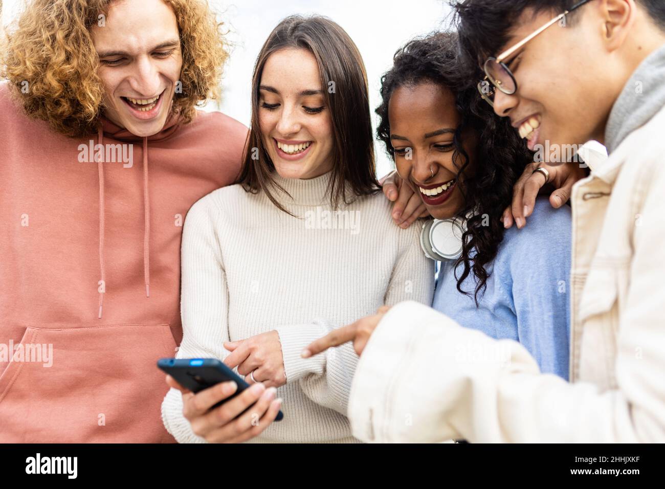 Millennial people laughing together while watching funny content on ...