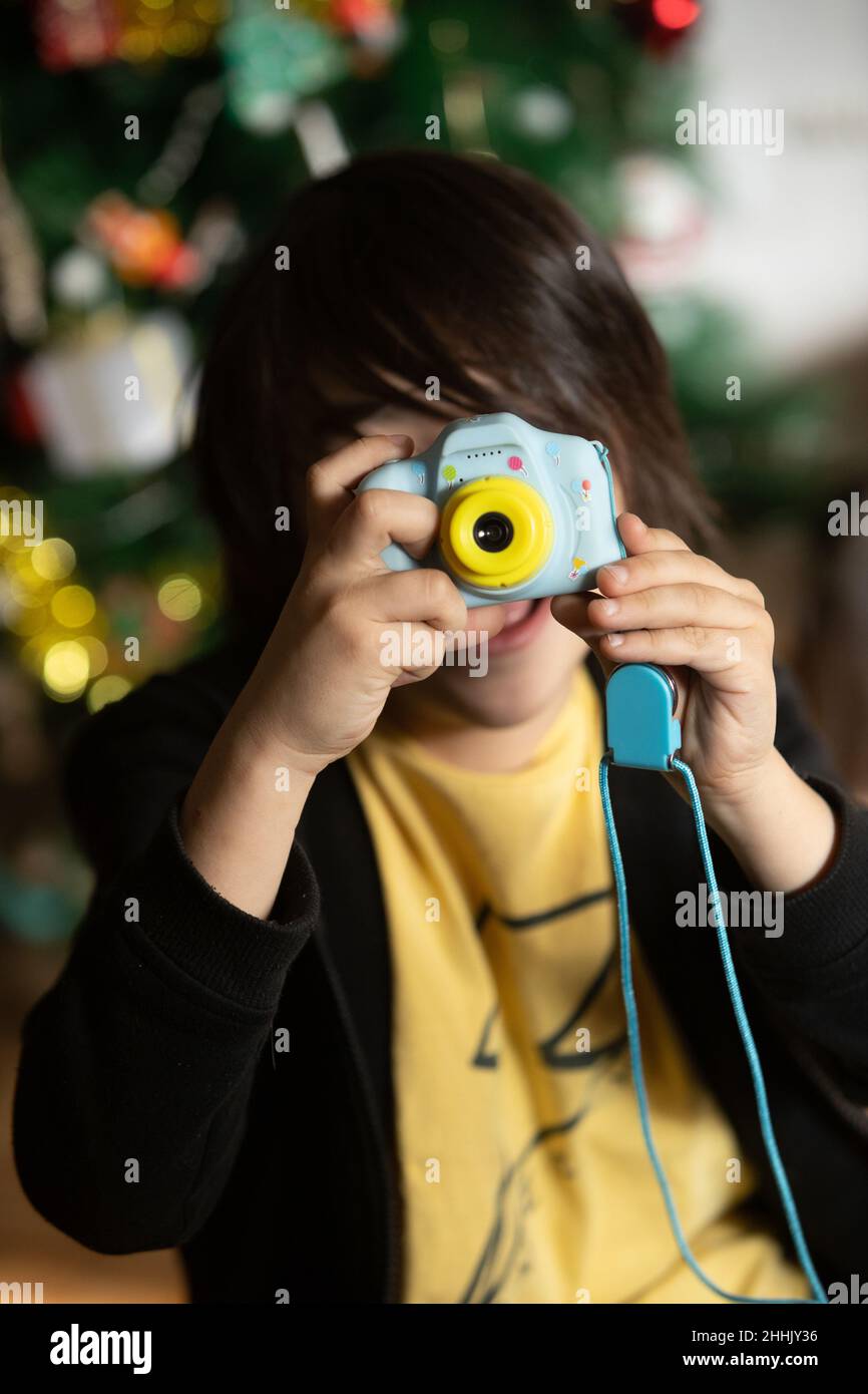 Anonymous boy with black hair playing while taking picture on toy photo ...