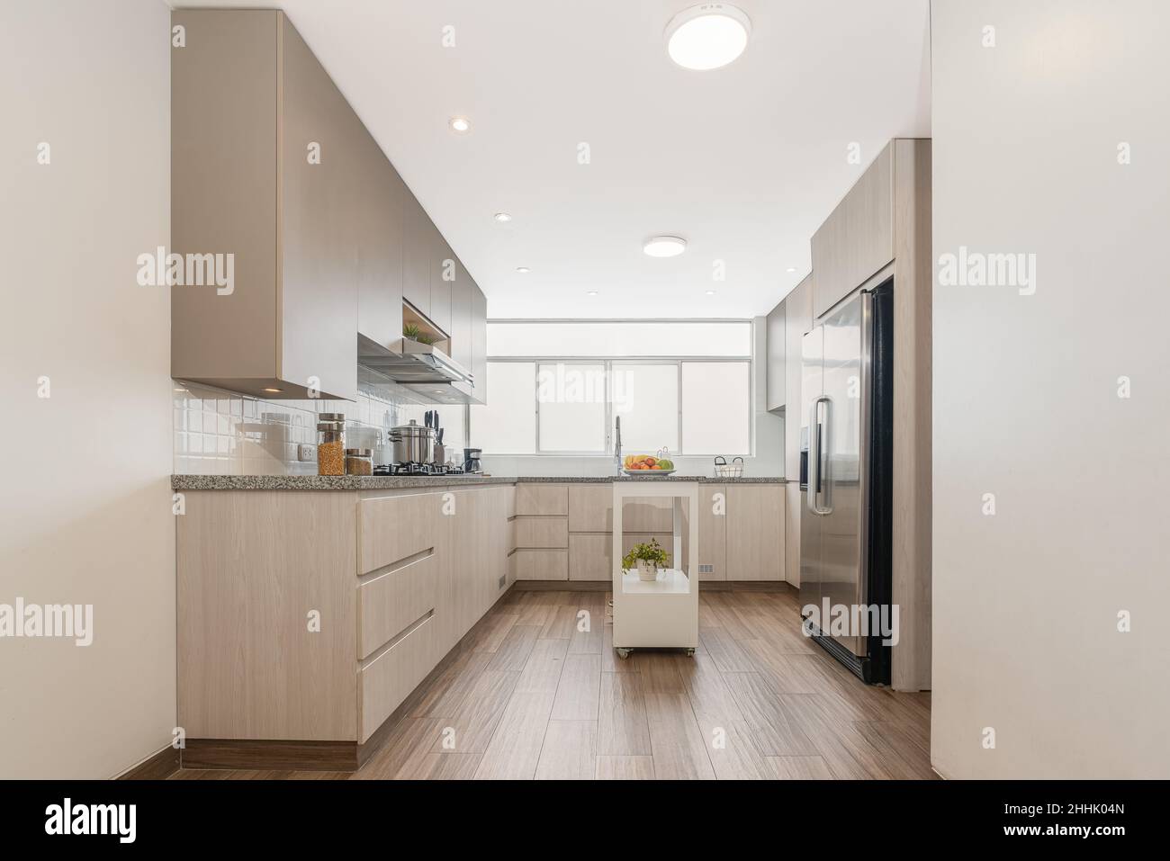 Counter with modern appliances and cabinets placed near fridge in ...