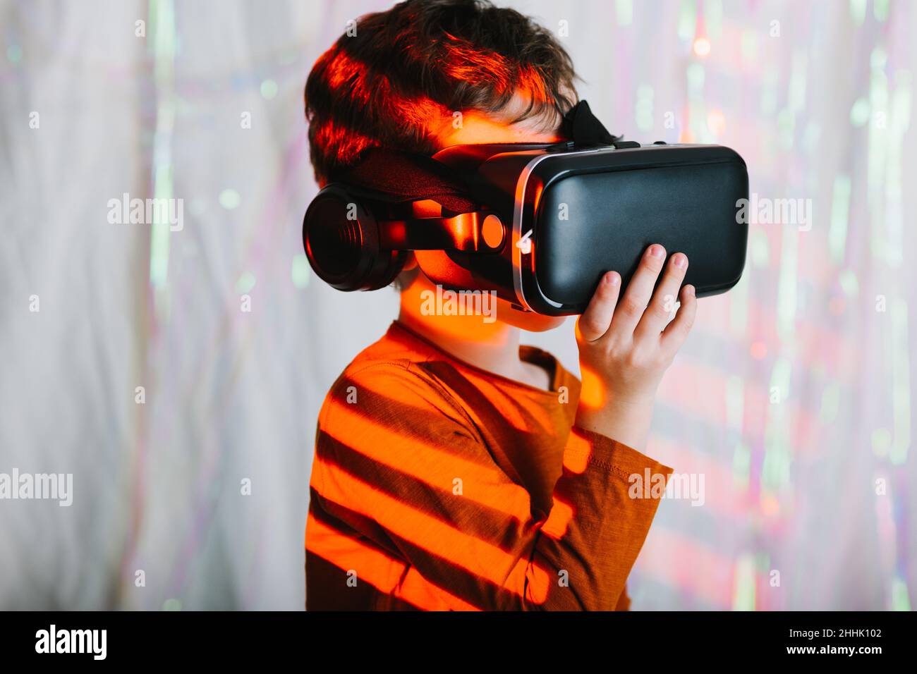 Side view of child in modern VR goggles experiencing virtual reality in ...