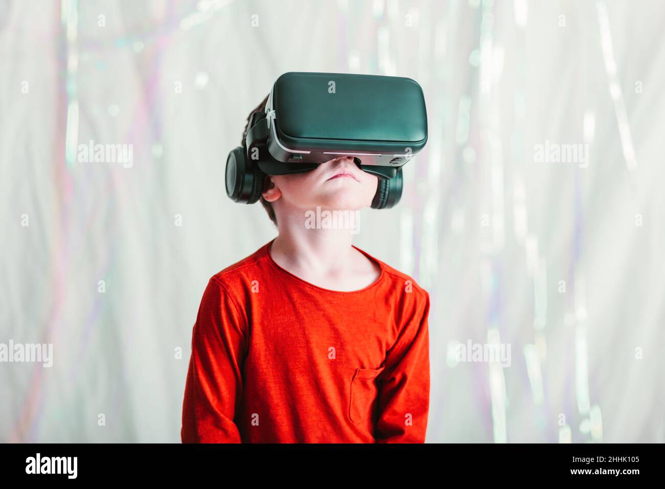 Child in modern VR goggles experiencing virtual reality in studio on ...