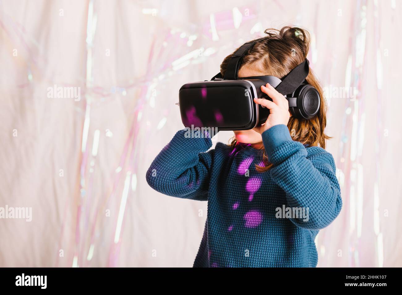 Side view of child in modern VR goggles experiencing virtual reality in ...