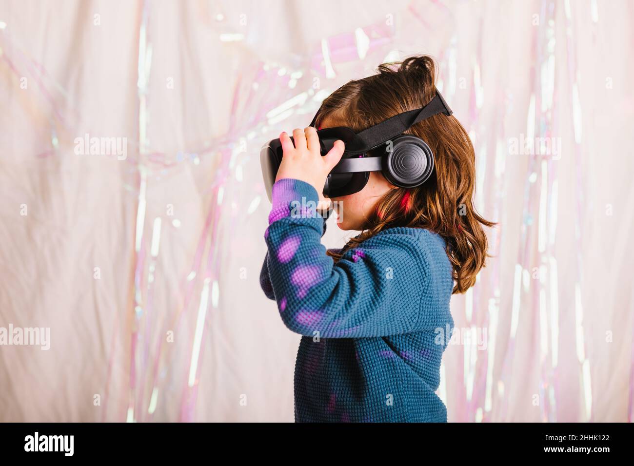 Side view of child in modern VR goggles experiencing virtual reality in ...