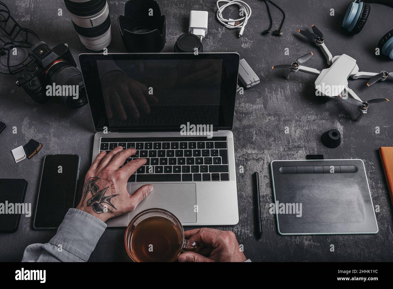 High angle of crop male photographer typing on netbook keyboard and ...