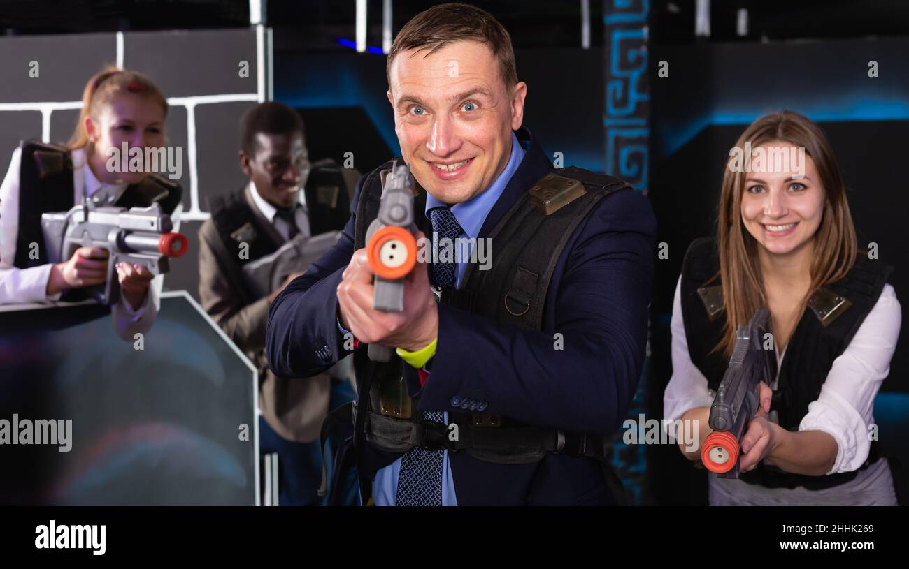 Modern man and his colleagues in laser tag room Stock Photo - Alamy