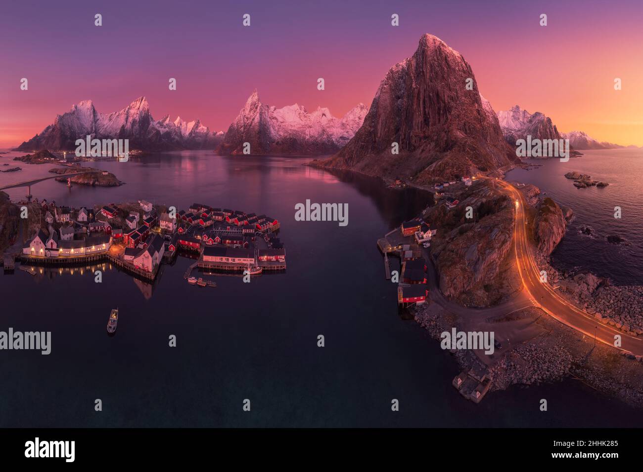 Aerial landscape of calm river and rocky formations located in Hamnoy under sunset sky in ...