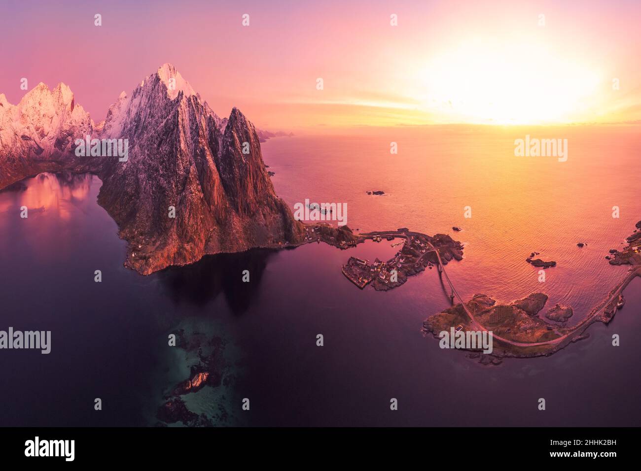 Aerial landscape of calm river and rocky formations located in Hamnoy under sunset sky in ...