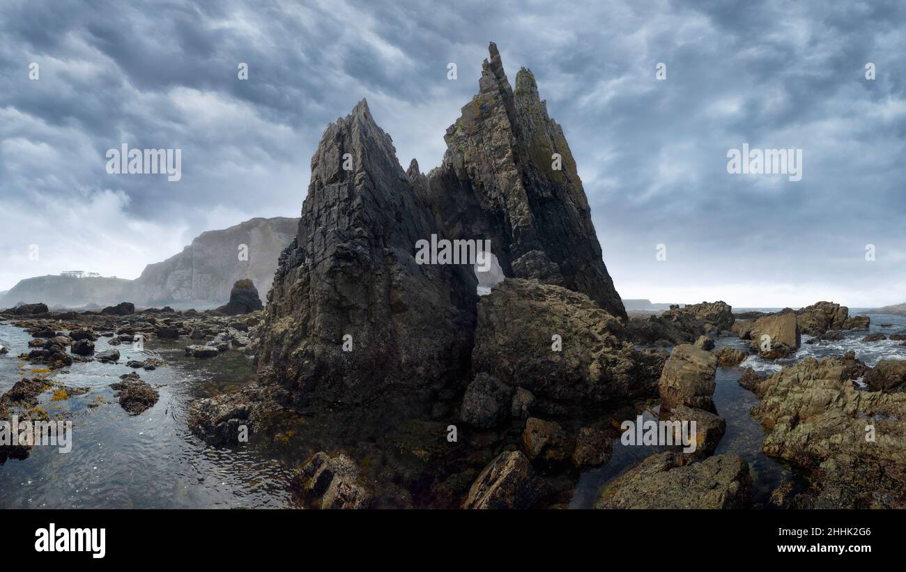 Beach with rough high rocky cliffs with uneven surface and boulders ...