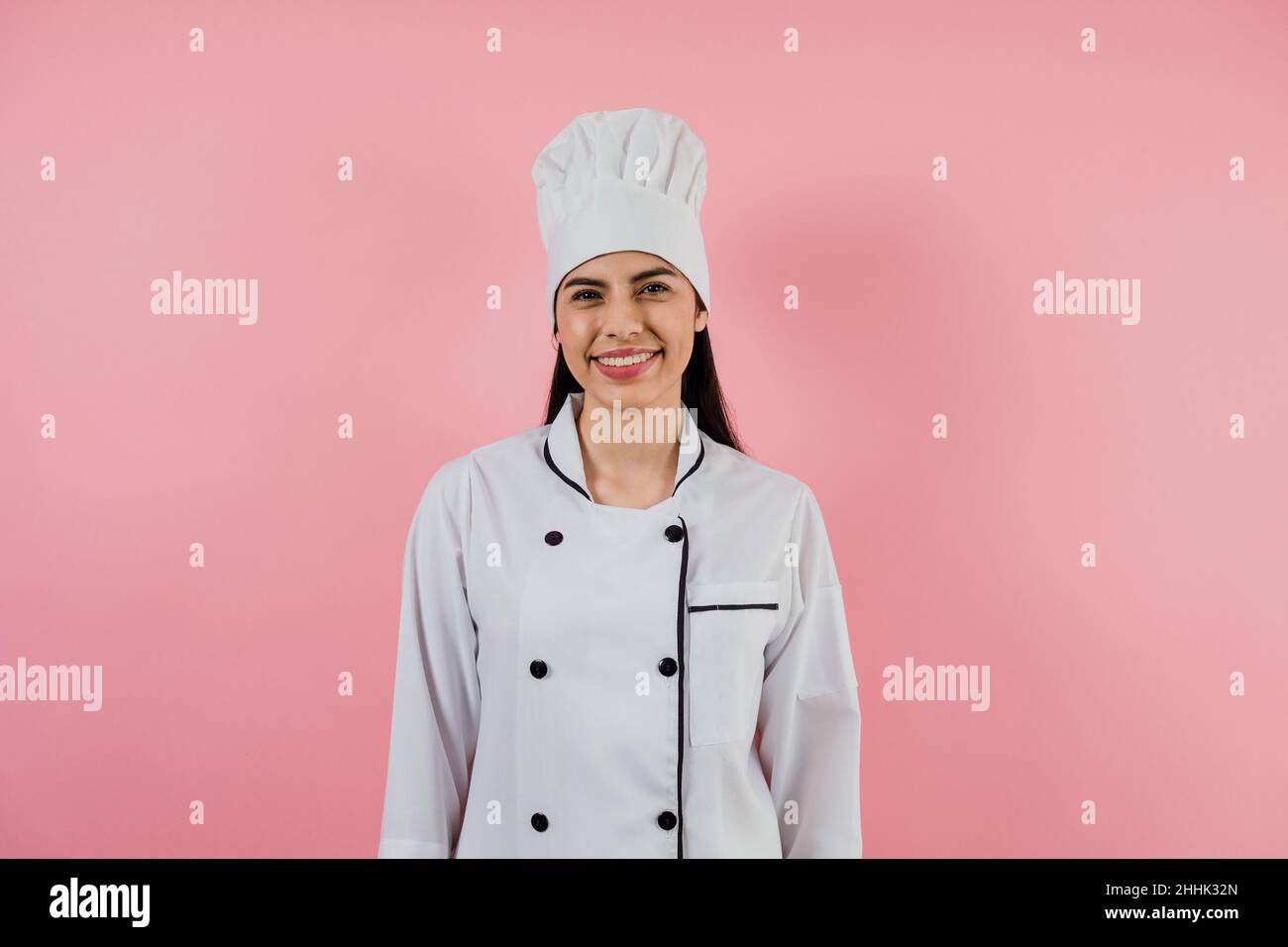 Portrait of young latin woman chef on a pink background in latin ...