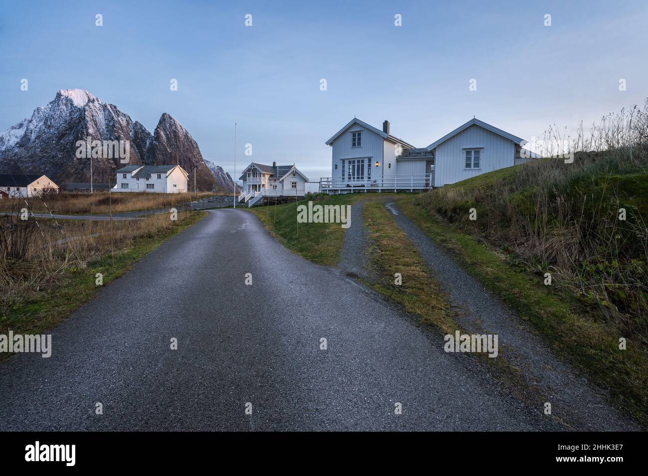From below of perspective view of narrow asphalt roadway among grassy ...