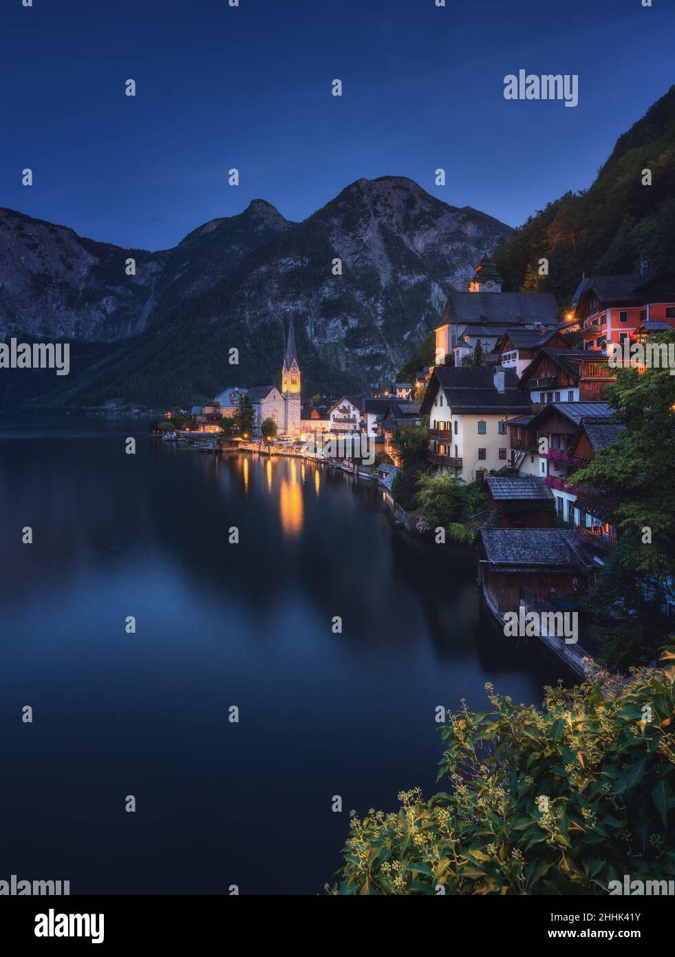 Hallstatt village with residential buildings with glowing lights ...