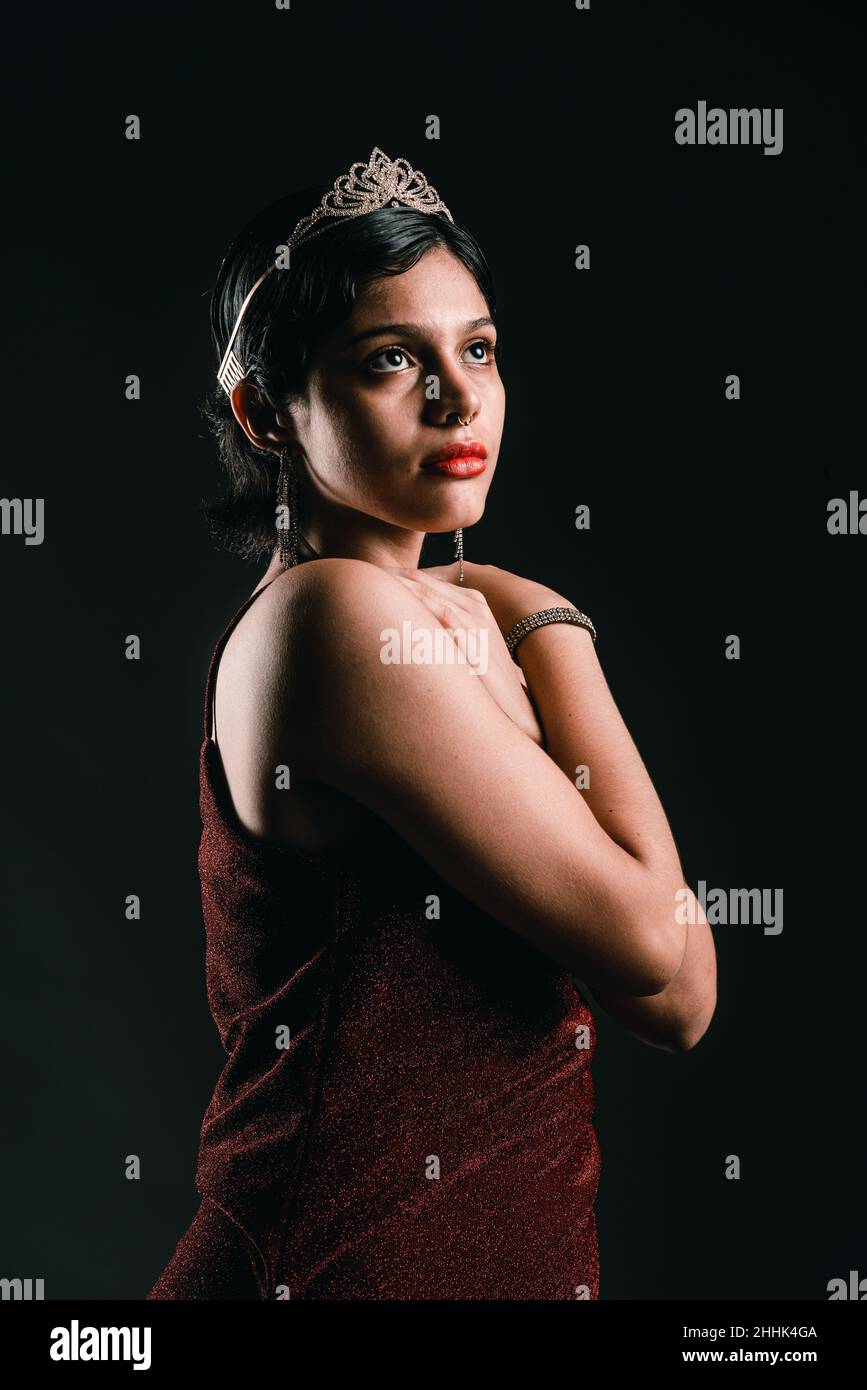 Side view of attractive alluring female wearing shiny dress and tiara ...