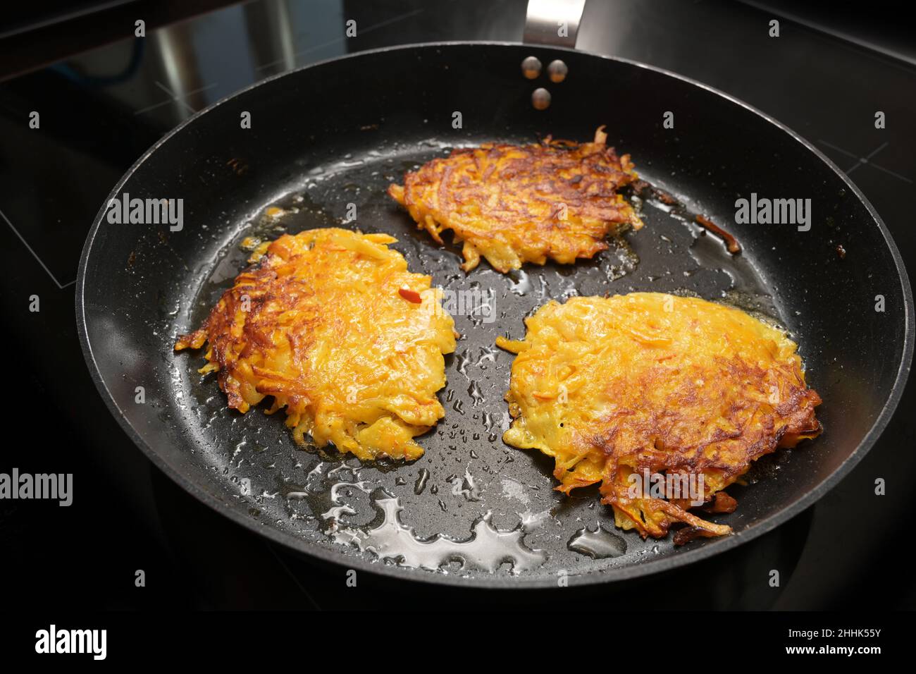 Roasted pancakes from red kuri squash and potato in a black pan, also ...