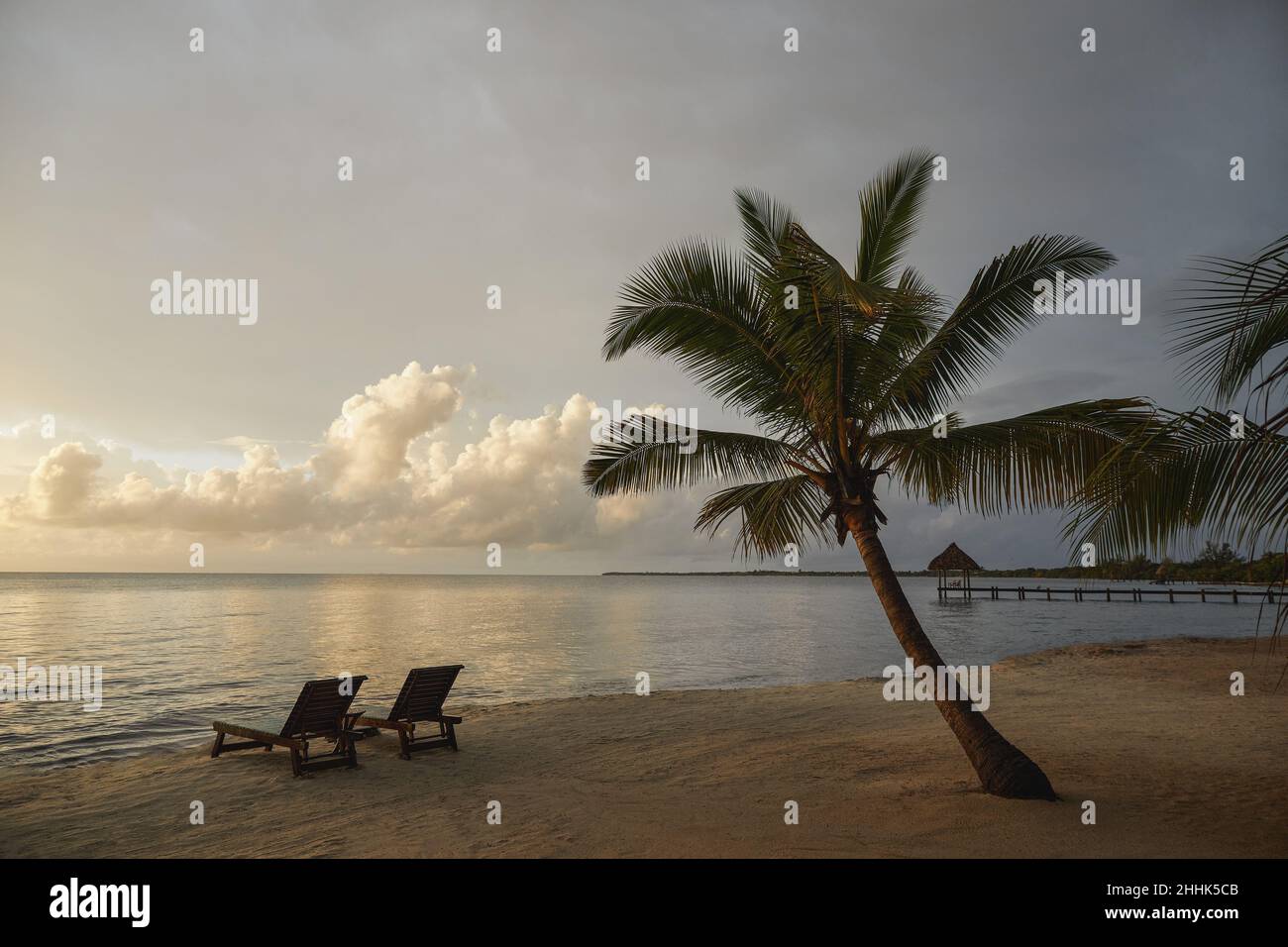 Belize, Placencia, Lounge chairs on tropical beach at sunset Stock ...