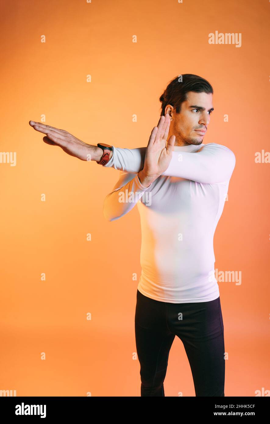 Serious young fit Hispanic male athlete with dark hair and beard in ...