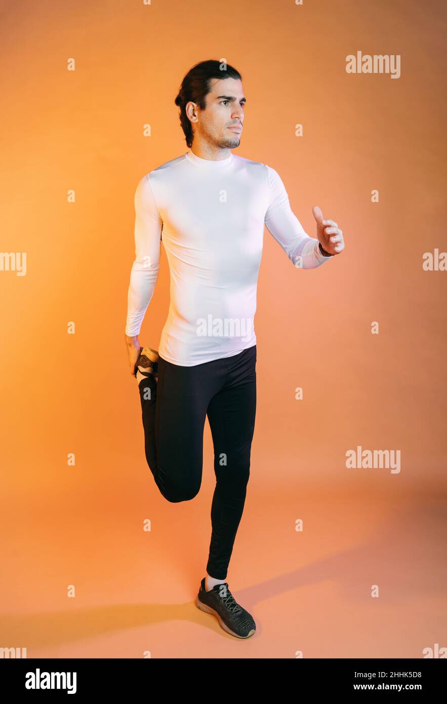 Full body of concentrated young fit Hispanic male athlete with dark ...