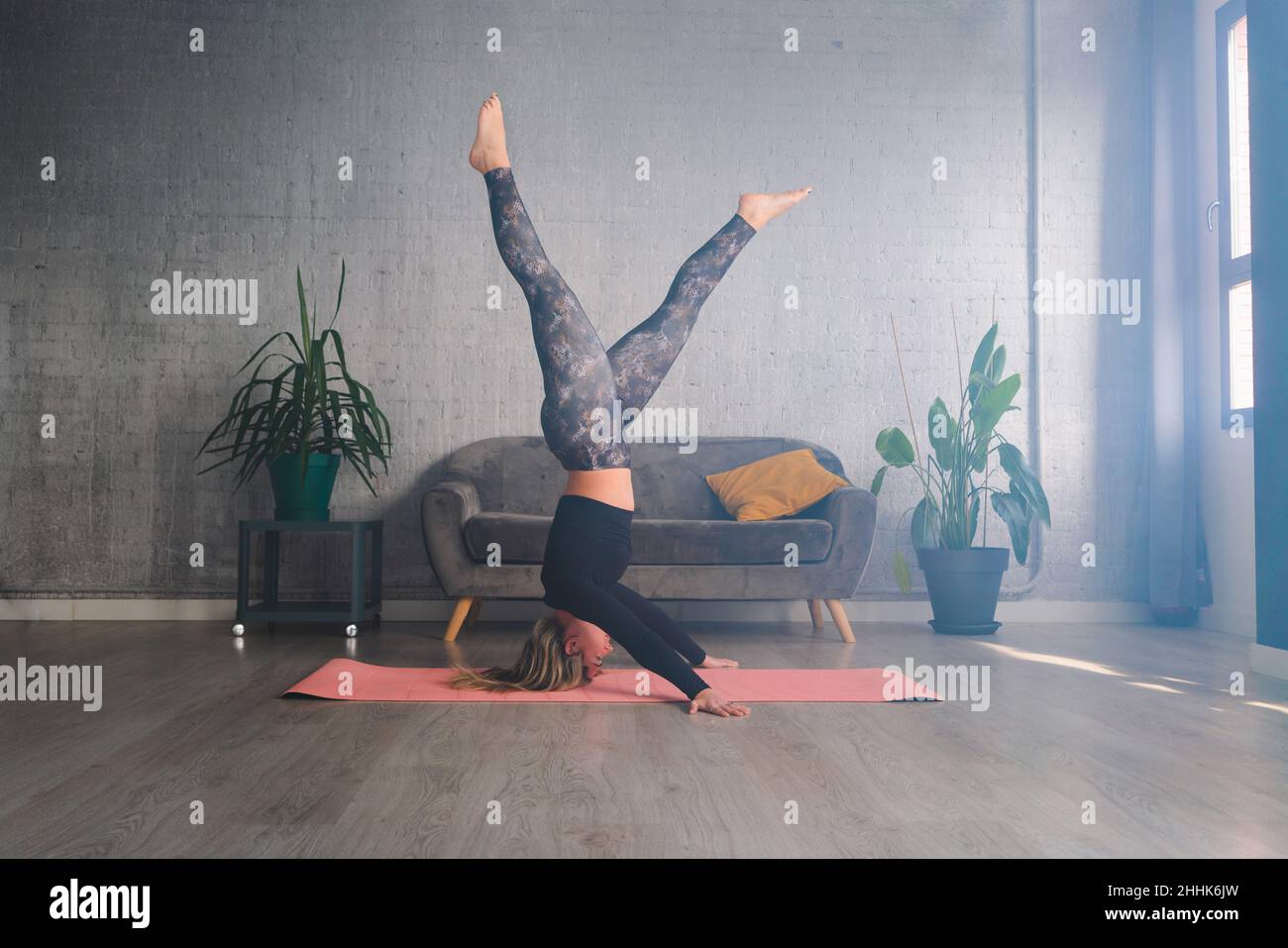 Full body side view of upside down barefoot female preparing for Mukta ...