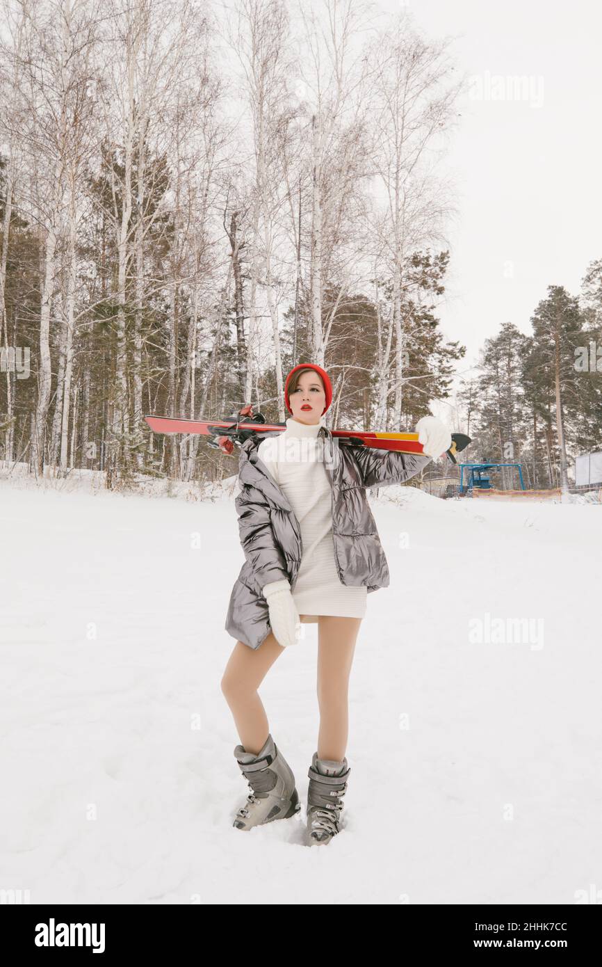 Fashion model girl posing with skis in the snow Stock Photo - Alamy