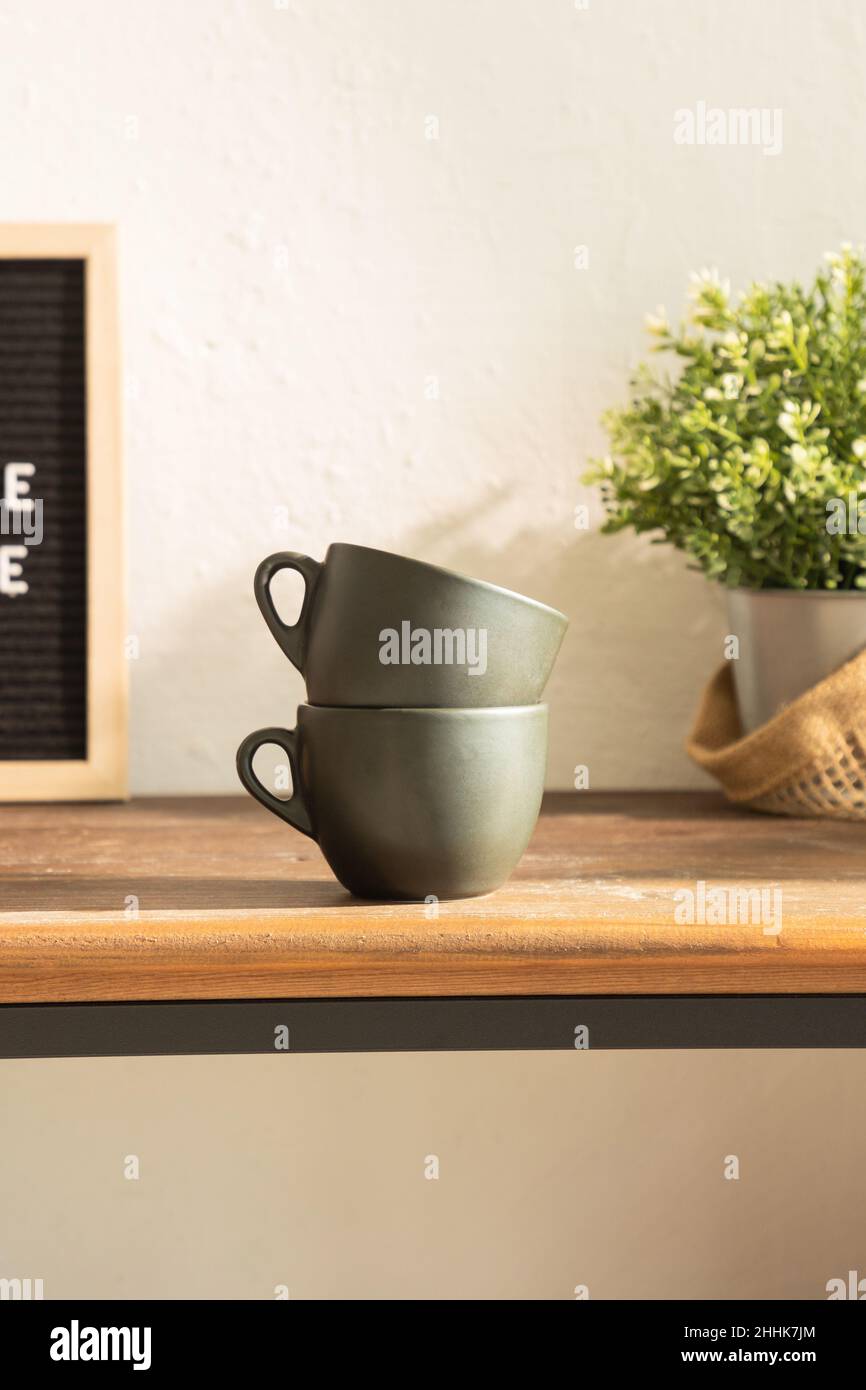 Mugs placed on each other on wooden counter with black signboard and ...