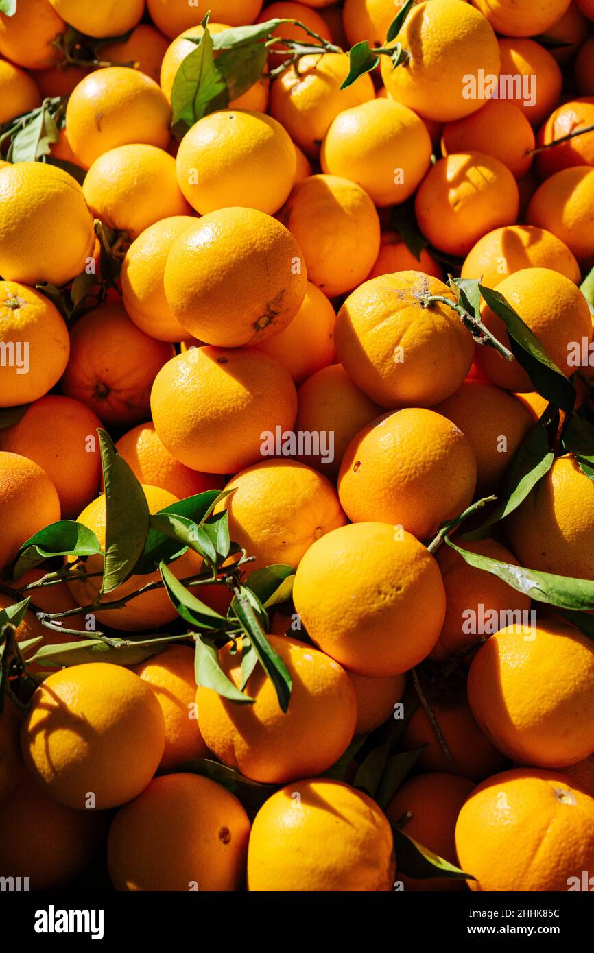 Full frame pile of fresh tangerines with green leaves placed on stall ...