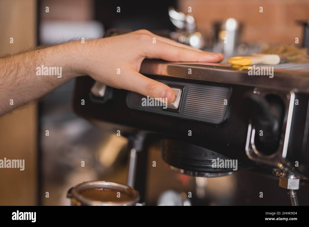 Crop anonymous male barista turning on professional coffee machine for ...