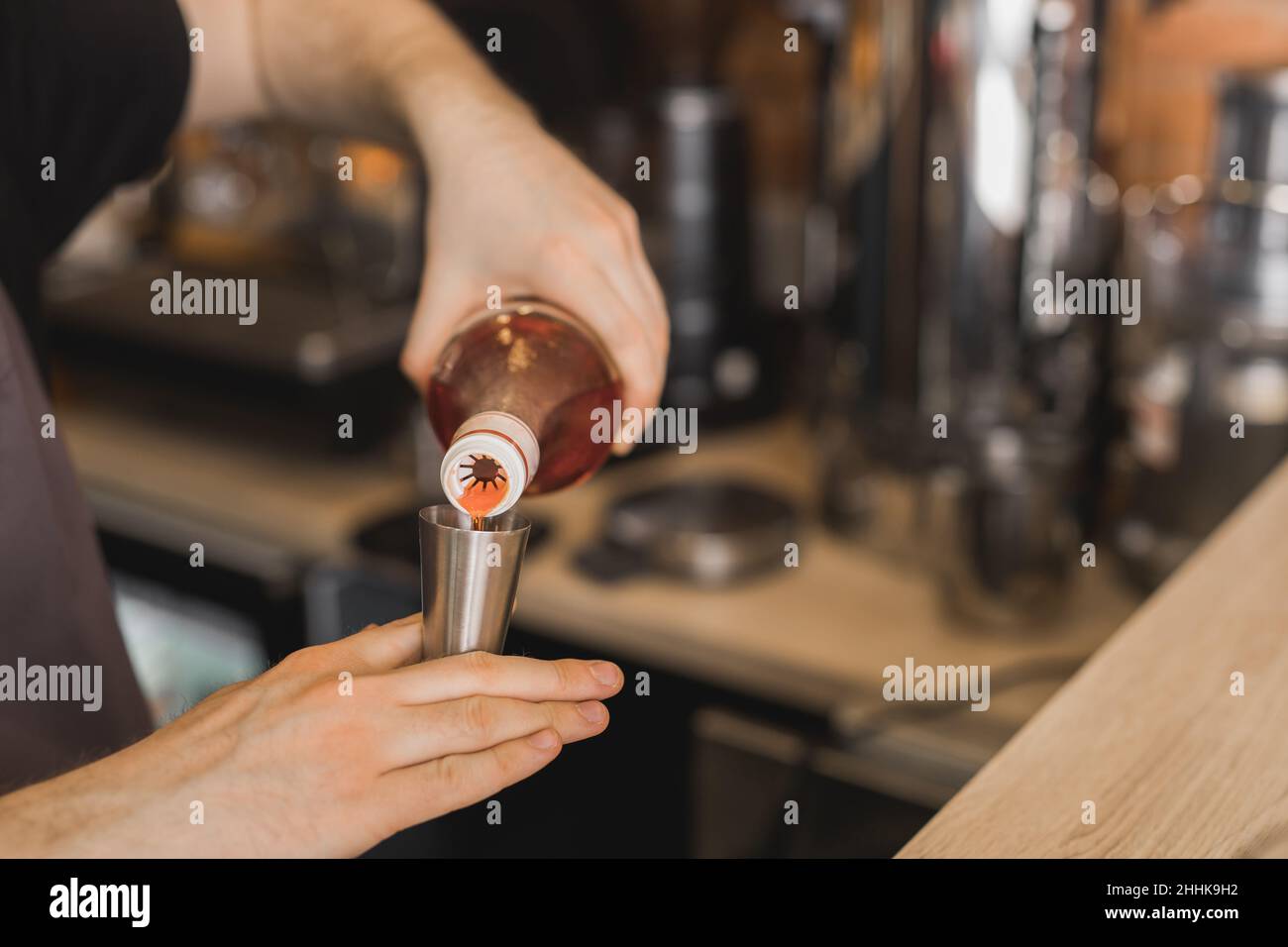 High angle of crop anonymous male barista in apron filling stainless ...