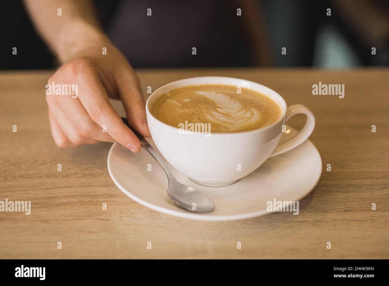 Crop male barista in apron serving cup of coffee while working at bar ...