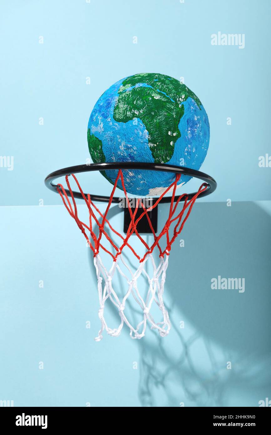 Round planet Earth with water and land in basketball hoop with colorful ...