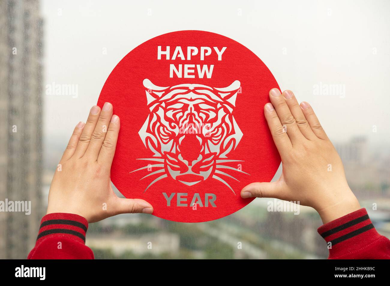 sticking a Chinese New Year of tiger 2022 mascot to the window ...