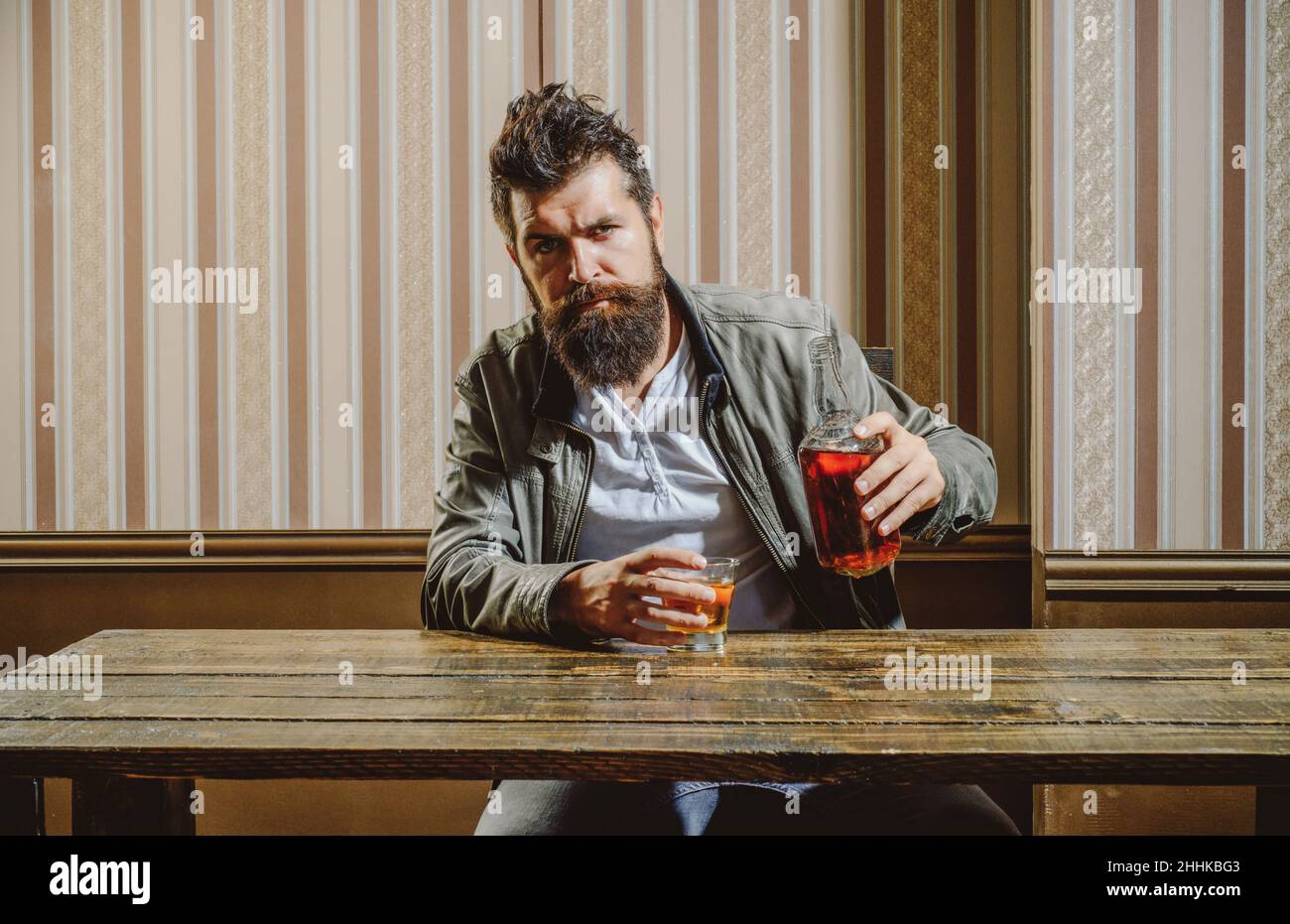 Man with beard holds glass brandy. Man holding a glass of whisky ...