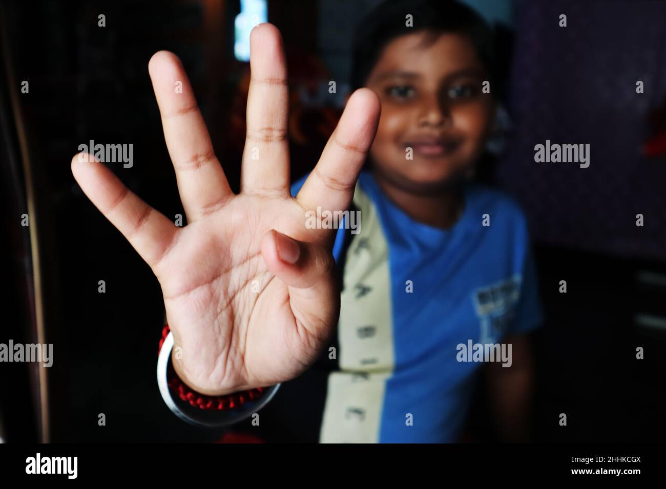A kid showing four fingers and hand with a smiling face Stock Photo - Alamy