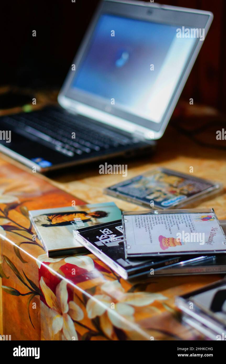 Closeup of an old music compact discs laying on a table next to an open ...