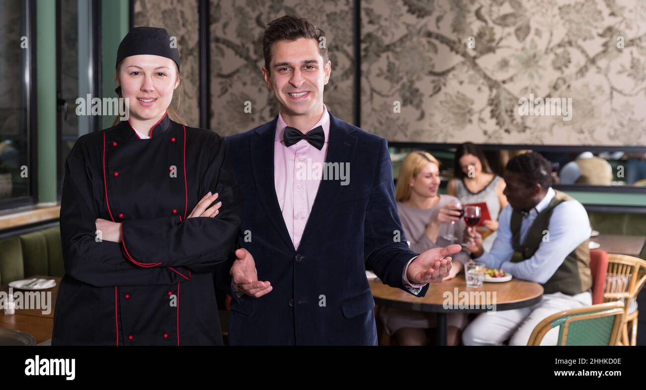 Female chef with waiter welcoming guests of restaurant Stock Photo - Alamy