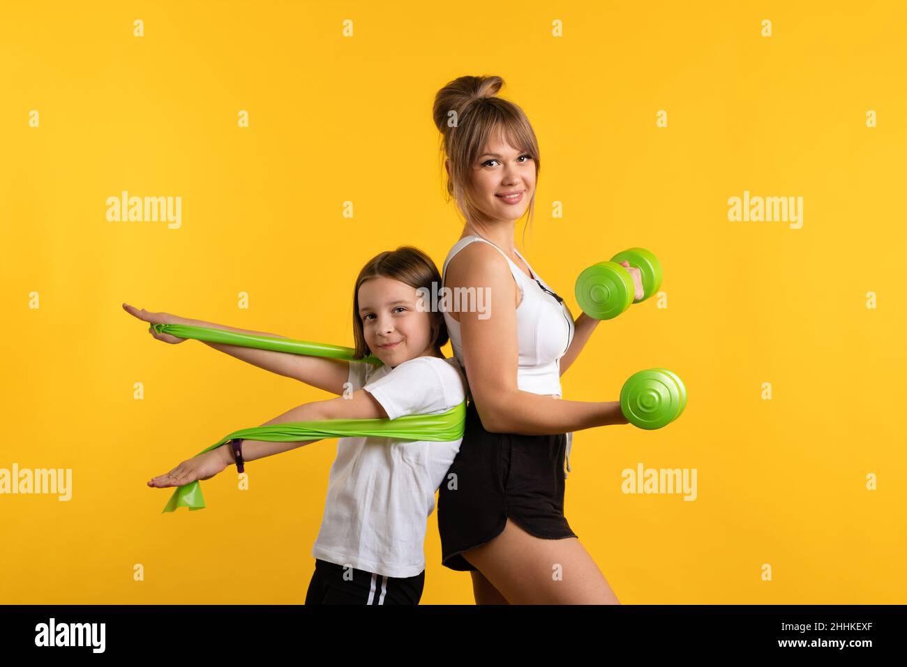 Healthy fit mom and daughter wearing sport wear in studio using ...